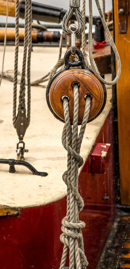 Vertical Shot of a Wooden Pully with Ropes Attached Stock Photo - Image ...
