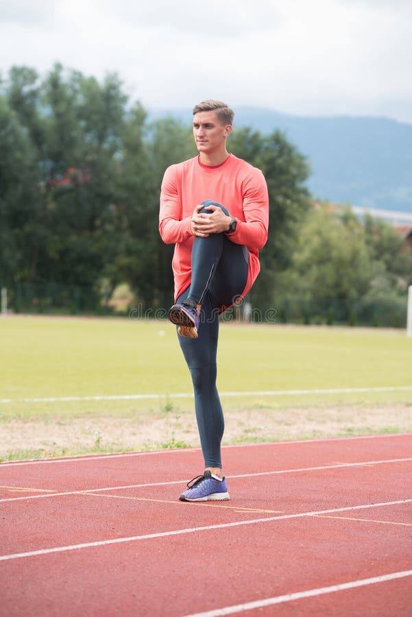Vertical Shot of a Young Caucasian Man Warming Up on a Running Track ...