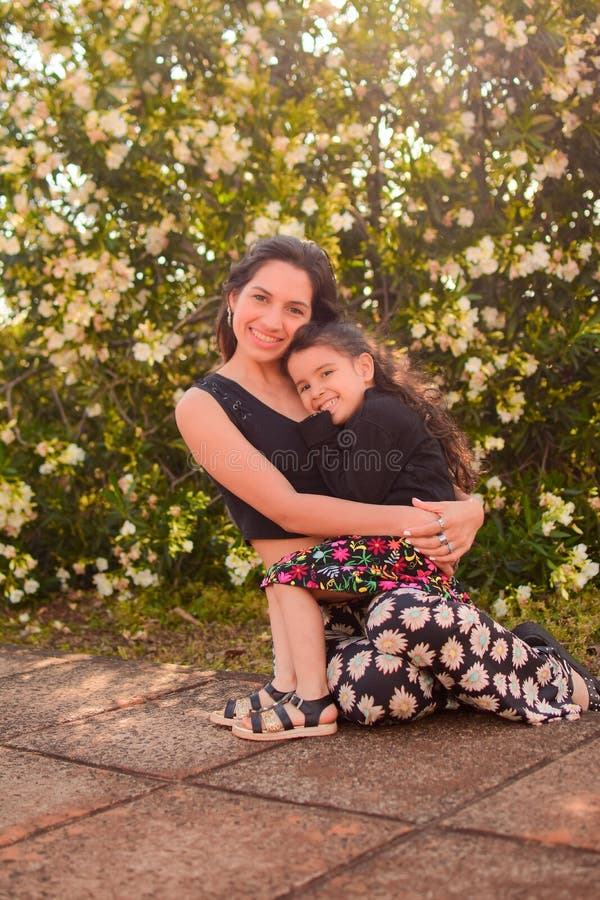 Vertical Shot of a Young Kid with Her Mom Posing in a Park in Daylight ...