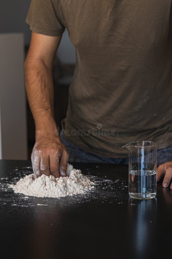 Vertical Shot of a Young Man Making Dough with Flour and Water Stock ...