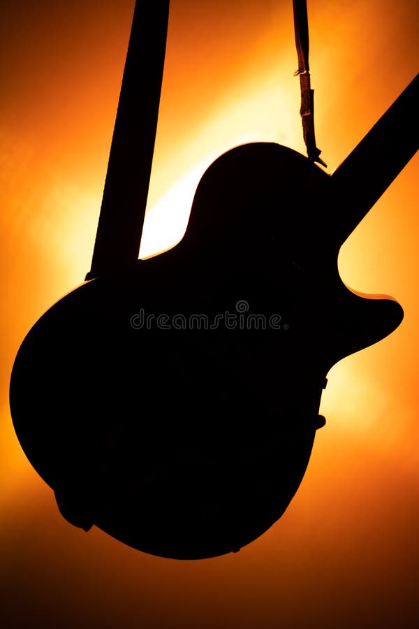 Vertical Silhouette of a Guitar Against an Orange Light Background ...