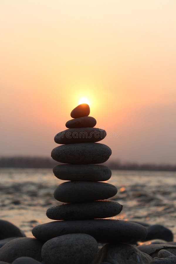 A Vertical Stack of Smooth, Rounded Stones Rests on a Pebbly Beach ...
