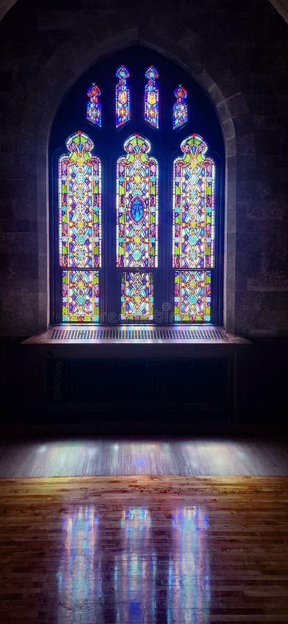 Vertical of a Stained Glass Window in a Dark Room Stock Image - Image ...