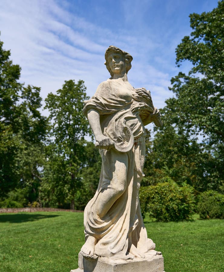 Vertical of a Statue of a Greek Goddess Captured in a Beautiful Green ...