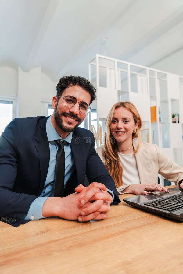 Vertical. Teamwork of Businesspeople Sitting on Desk and Looking at ...
