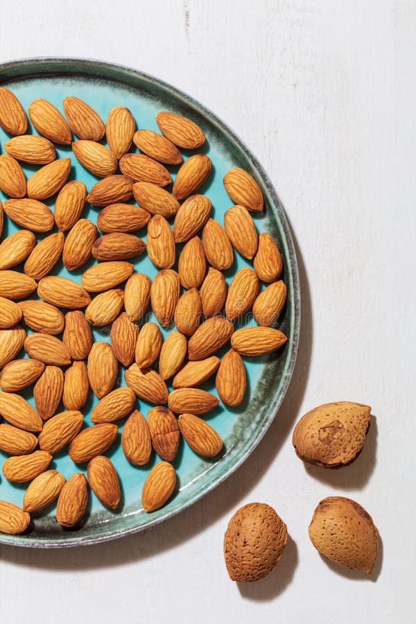 Vertical Top View of Almonds in a Plate and in Shell Almonds Next To it ...