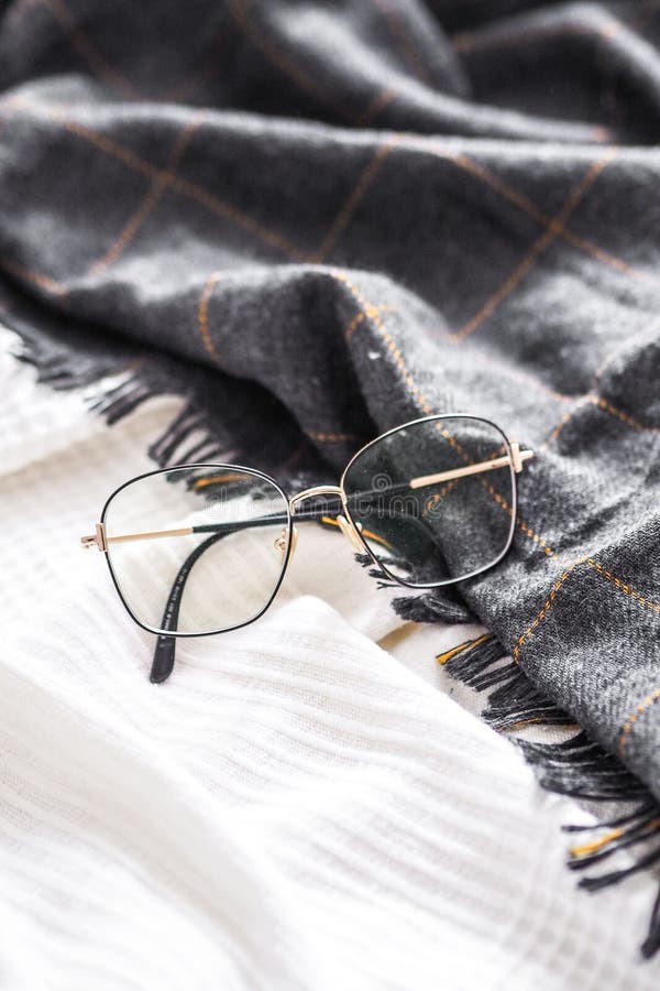 Vertical Top View of Eyeglasses on a White Comforter and a Black ...