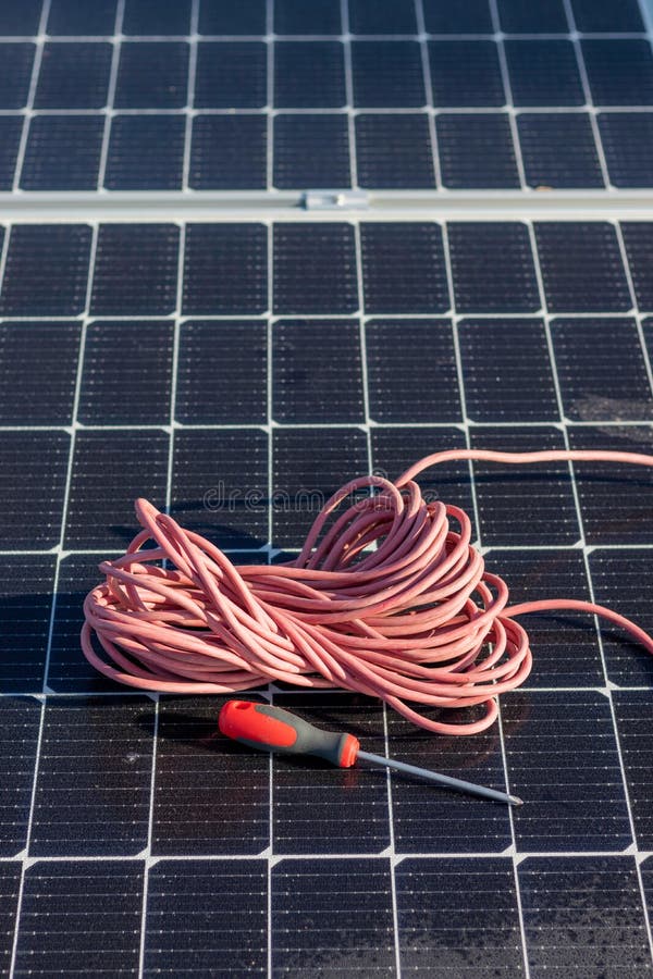 Vertical Top View of Red Cable Reel and a Screwer Leaning on a Solar ...