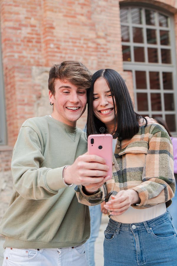 Vertical. Two Student People Having Fun with a Mobile Phone Outdoors ...