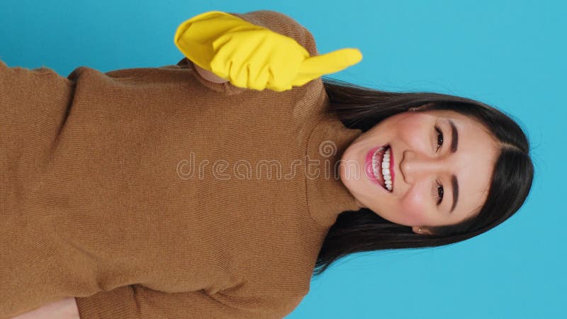 Vertical Video: Joyful Maid Posing in Studio Doing Approve Gesture in ...