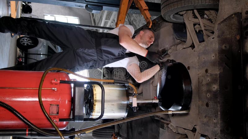 Vertical Video a Man Fixing Car Underneath in Garage, Focused with ...