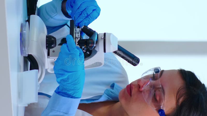 Vertical Video: Scientist Placing a Slide on Specimen Stage of a ...