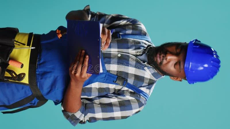 Vertical Video: Young Handyman Making Calculations on Files Stock Video ...