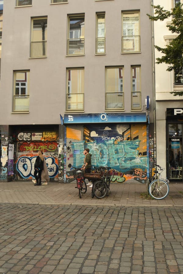Vertical View of Bicycles and People before the Buildings with Graffiti ...