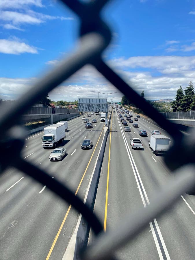 Vertical View Down the Freeway HWY 880 through a Chain Link Fence ...