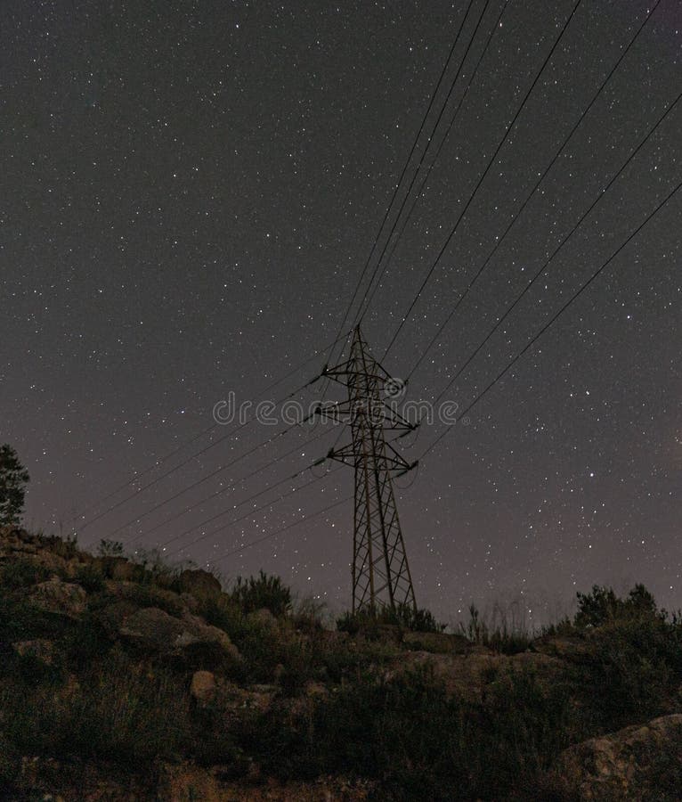 Vertical View of an Electricity Column Over the Hill Under the Starry ...