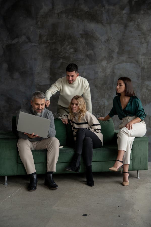 Vertical View of the Focused Colleagues Sitting Green Sofa and Looking ...