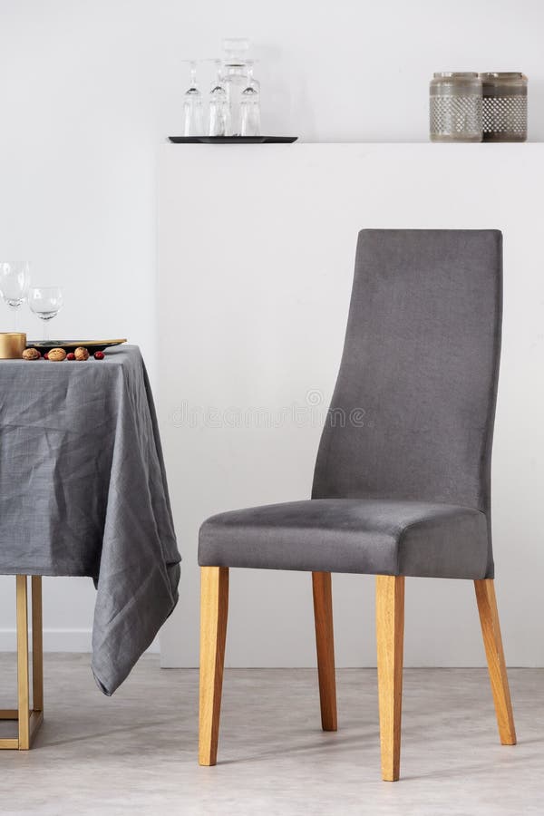 Vertical View of Grey Chair Next To Dining Table in White Interior ...