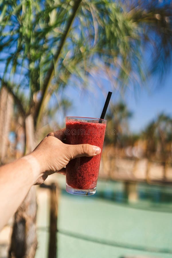 Vertical View of a Hand Holding the Glass of Red Cold Drink at the ...