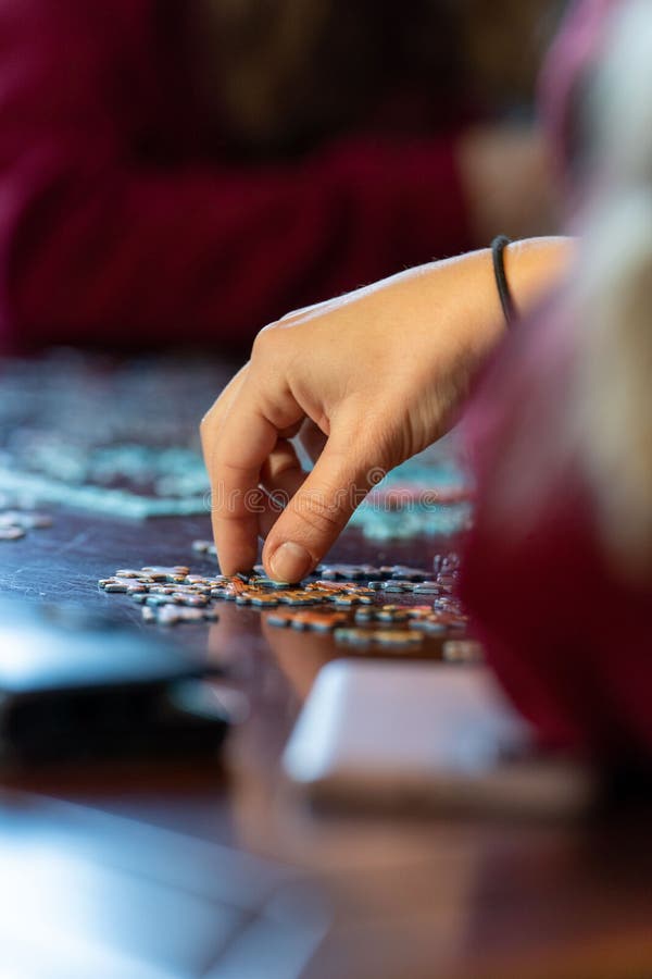 Vertical View of a Hand Picking Up Pieces of a Mosaic Puzzle Stock ...