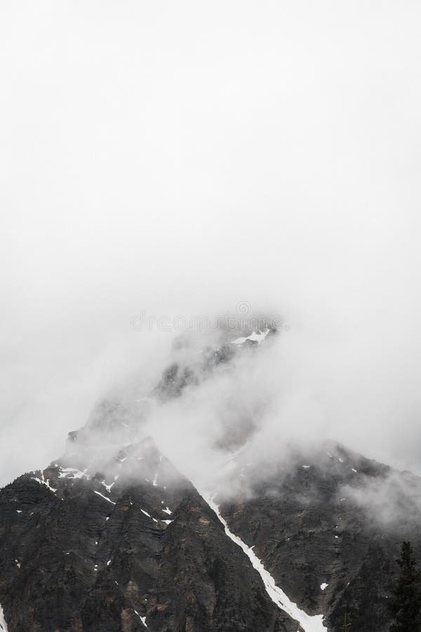 Vertical View of the Peak of a Mountain Hidden by Clouds Stock Photo ...