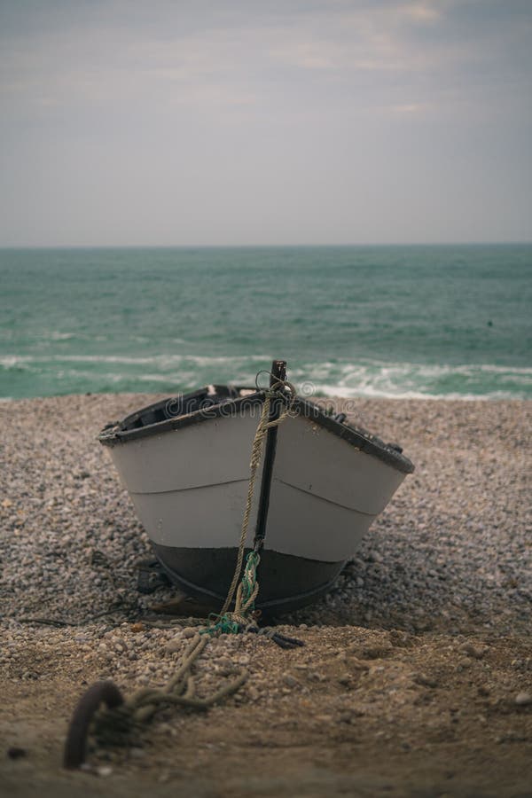 Vertical View of a Row Boat on the Beach with the Ocean Behind it Stock ...