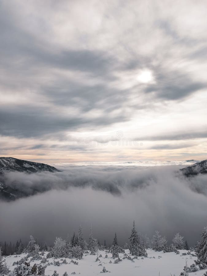 Vertical View of the Snowy Mountains Hidden in the Fog Stock Image ...
