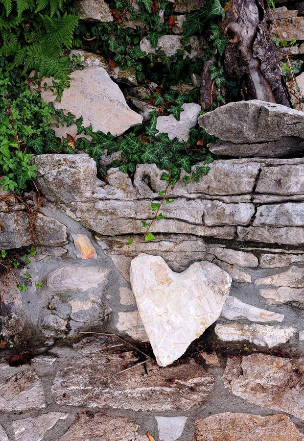 Vertical View of a Stone Heart Over the Rough Surface with Green Leafy ...