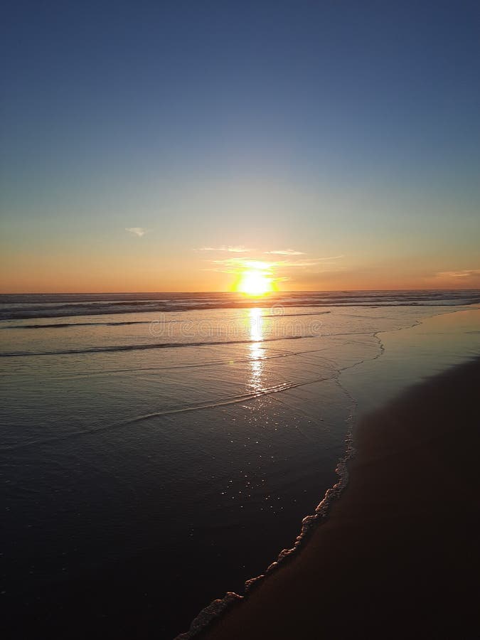 Vertical View of the Sunset at a Beach with Reflection of the Full Sun ...