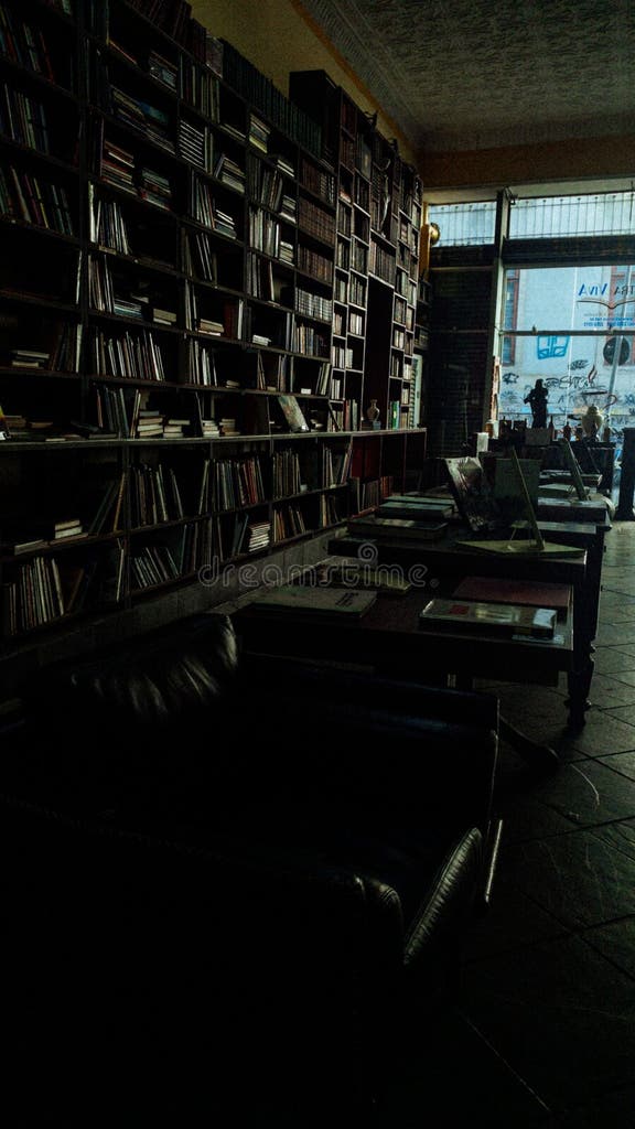 Vertical View of Tables in Front of the Bookshelf on the Wall in a ...