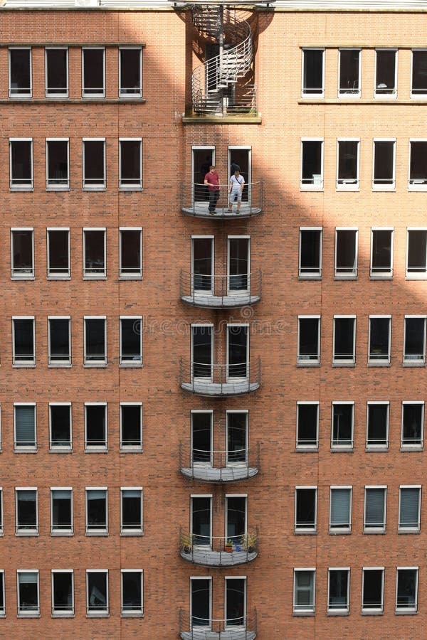 Vertical View of Two Men Standing on the Balcony of a Brick-built ...