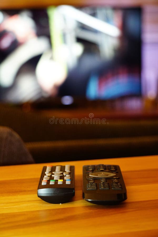 Vertical View of Two Television Remote Controllers on the Wooden Table ...