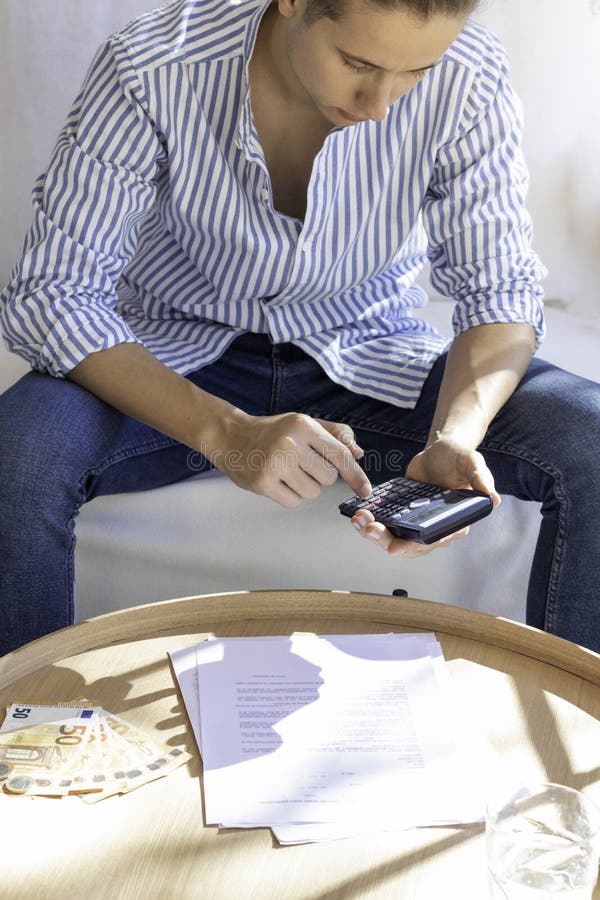 Vertical View of Young Man Sitting in the Couch Doing Calculations and ...