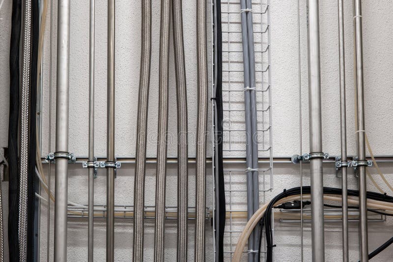 Vertical Wall Mounted Pipes and Electrical Cables in an Industrial ...
