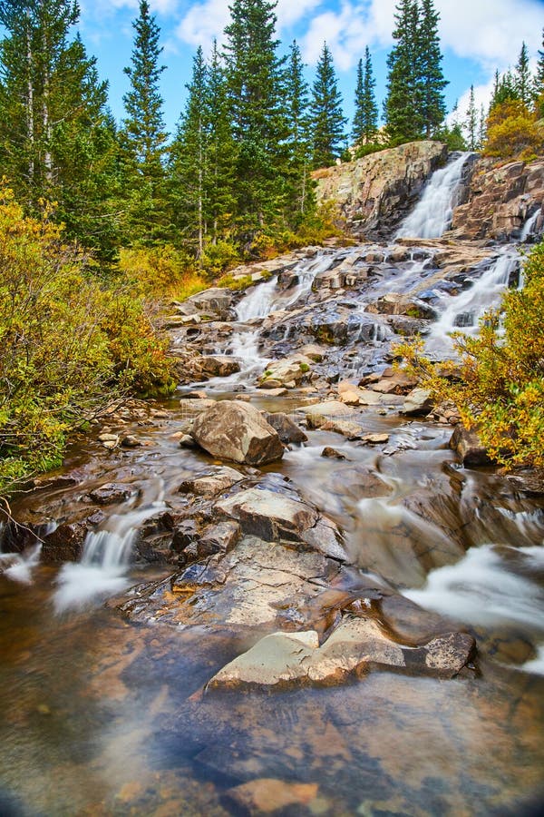Vertical of Waterfall Cascading Down Gray Rocks in Valley Stock Photo ...