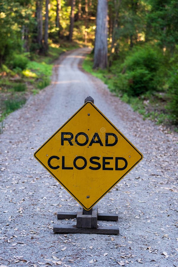 Vertical of Yellow Road Closed Sign in the Middle of a Road in the ...