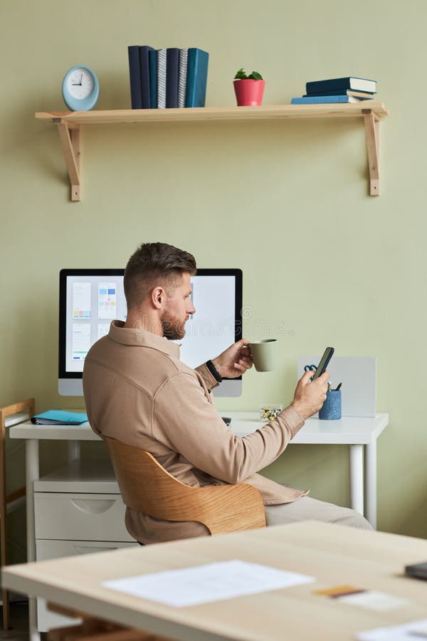 Vertical Young Man Using Smartphone Taking Break at Workplace in ...