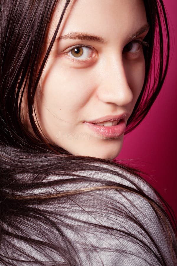 Verticale De Fille De Brunette Avec Le Long Cheveu Au Dessus Du Rose