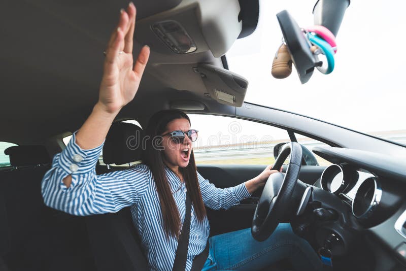 An Angry Young Girl Drives a Car and Points with Her Hands Stock Photo ...