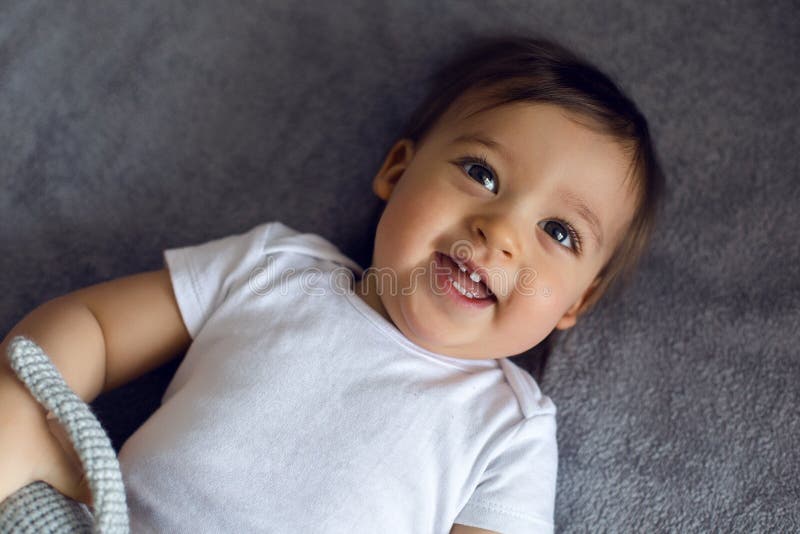 Very Cheerful Baby Boy in White Clothes Lying on the Bed Stock Photo ...