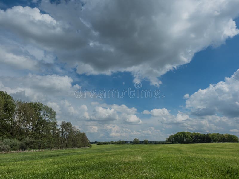 Very Cloudy Sky Over a Green Meadow Stock Photo - Image of tree ...