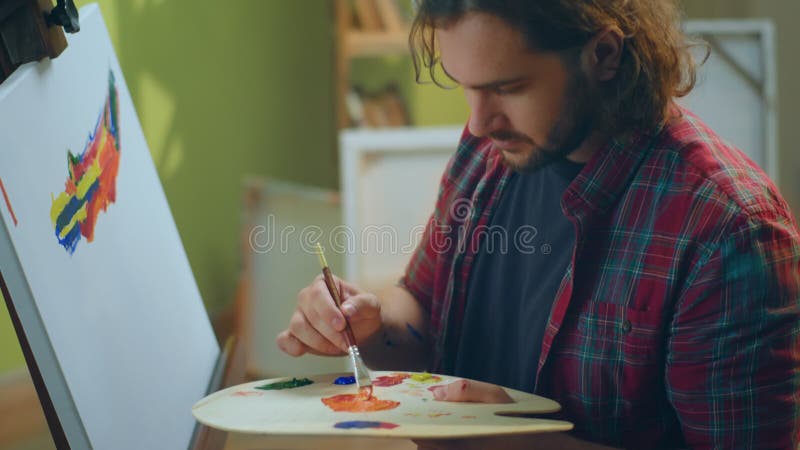 A Very Handsome Painter with Steady Hands is Mixing Paint on His ...