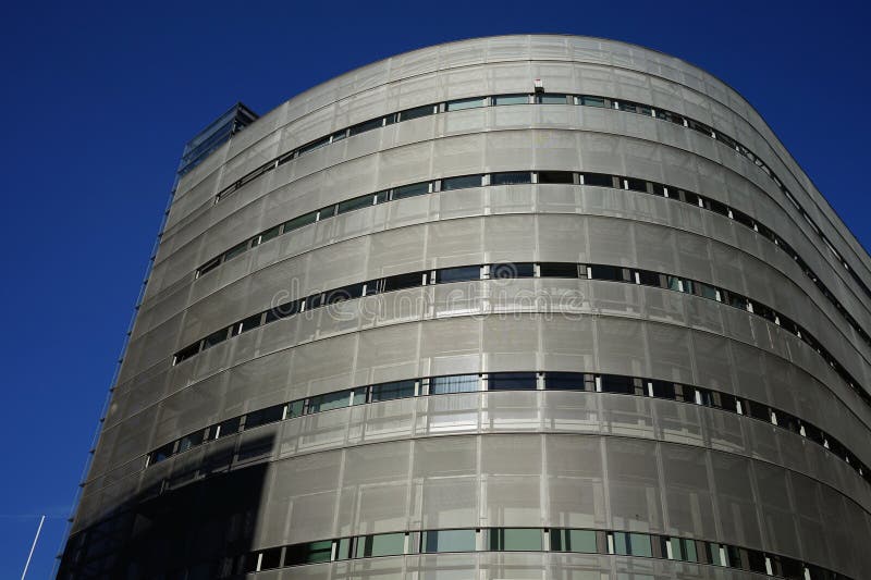 This is a Very Large, Curved Building with Windows and a Clock Stock ...