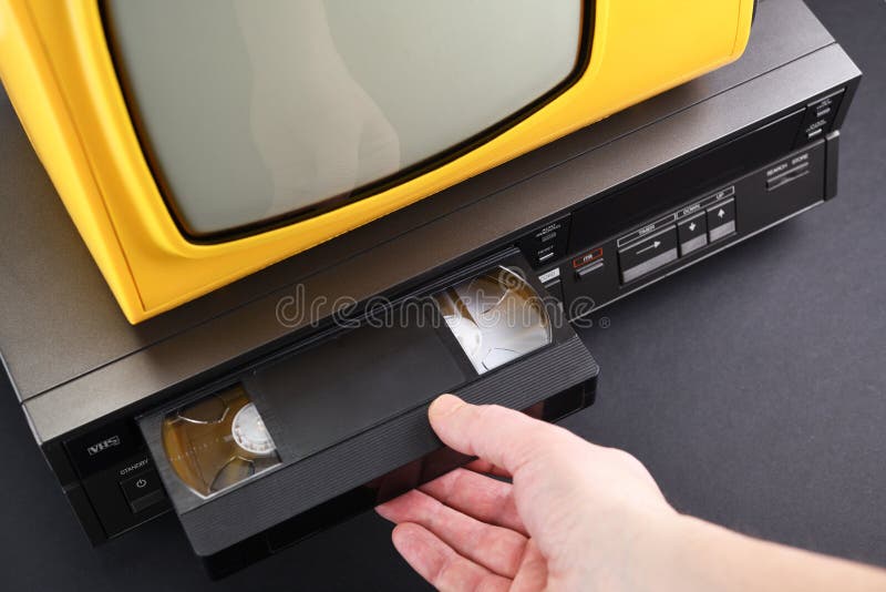 VHS Videotape is Inserted into a VCR To Watch a Video Recording. Stock ...
