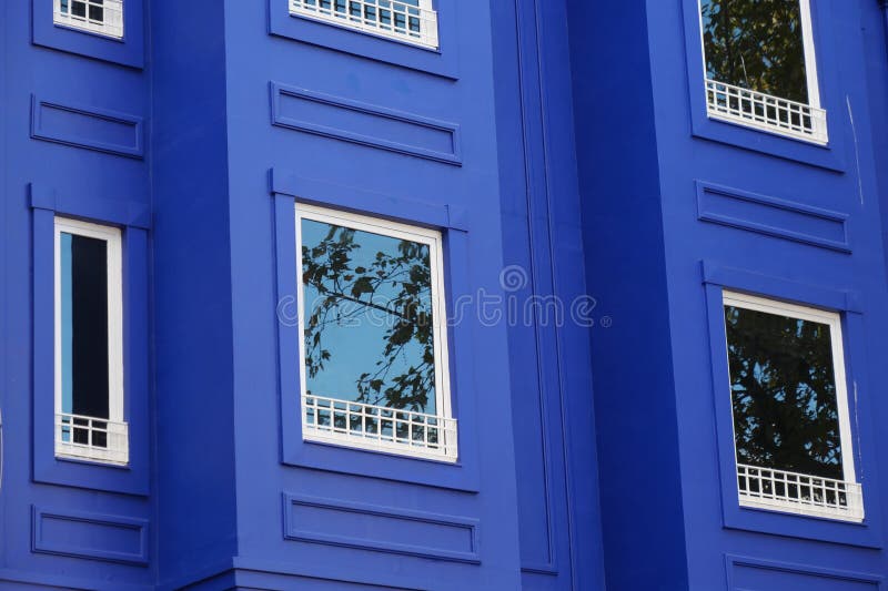A Vibrant Blue Building Featuring Reflective Windows and Modern ...