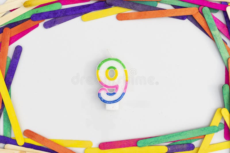 Vibrant Number Nine Candle with Popsicle Stick Border on White ...