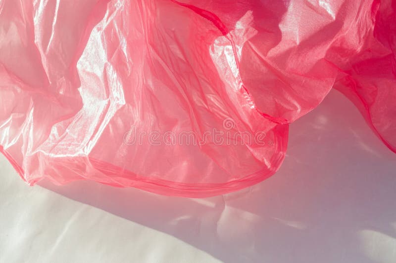 A Vibrant Pink Plastic Wrap Flows Gently Across a White Surface. the ...
