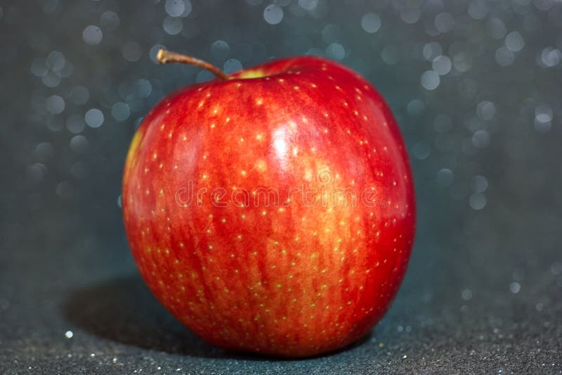 Fresh Red Apple Resting on a Black Surface with Sparkles and Soft ...