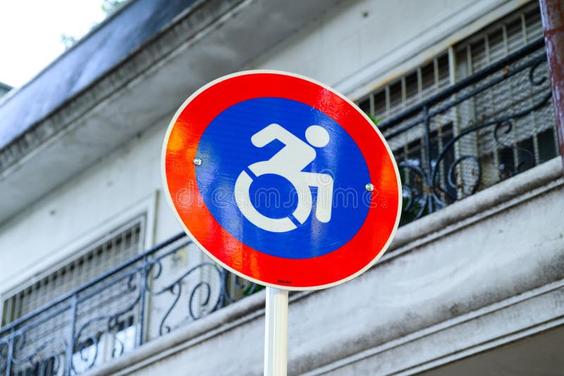 A Vibrant Red and Blue Sign Displaying a Person Using a Wheelchair ...
