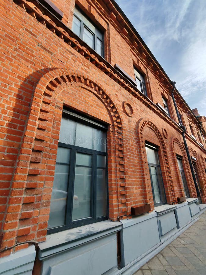 A Vibrant Red Brick Wall with Arched Window Frames and Decorative Brick ...